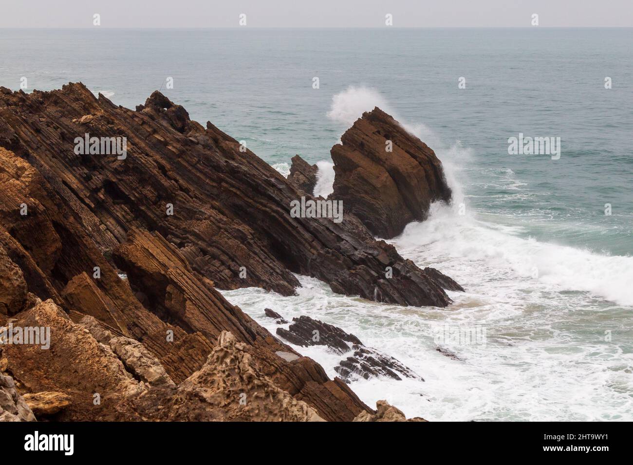 A wave hitting a rock in the sea Stock Photo - Alamy