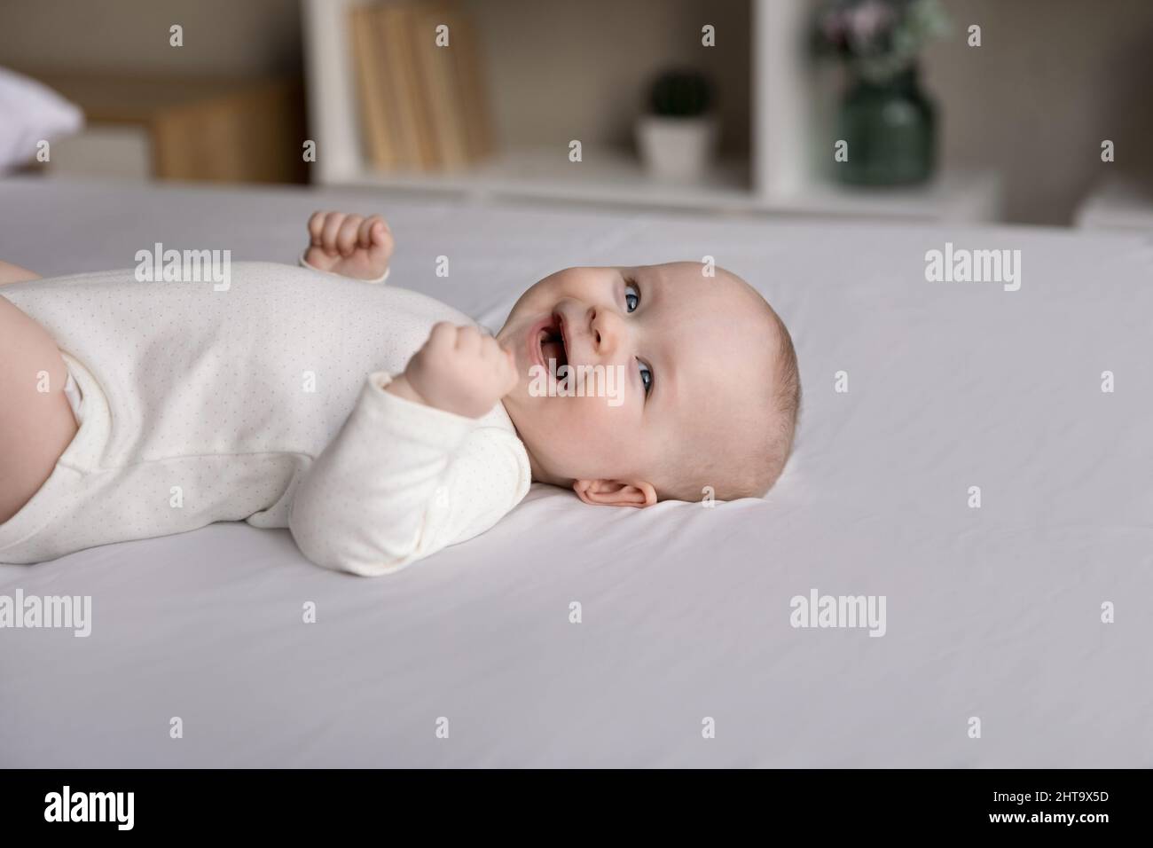 Happy cheerful few month baby resting on white linen Stock Photo - Alamy