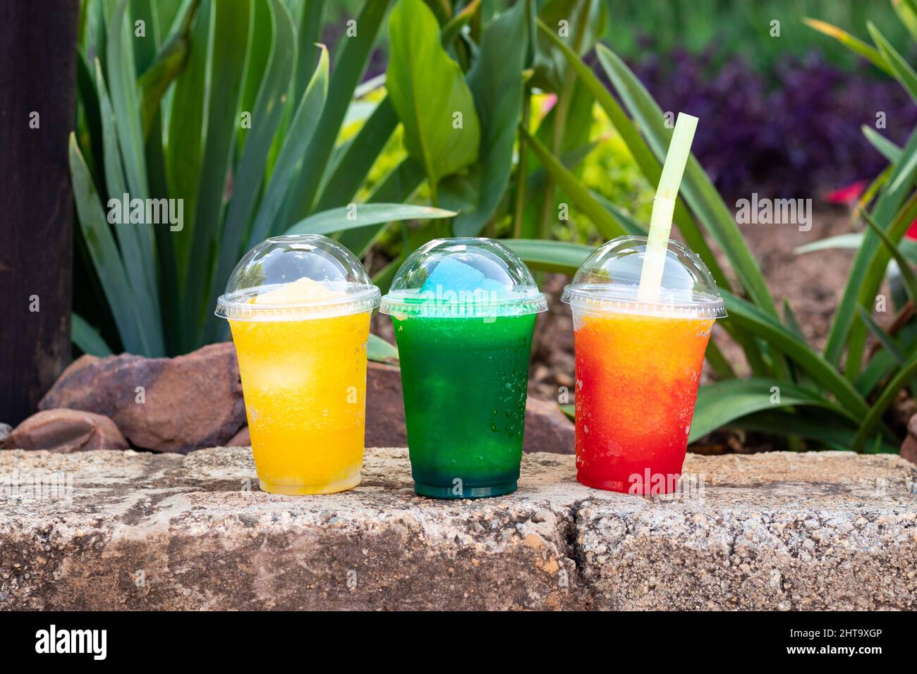 Closeup of three cold and refreshing slushies on a concrete brick ...