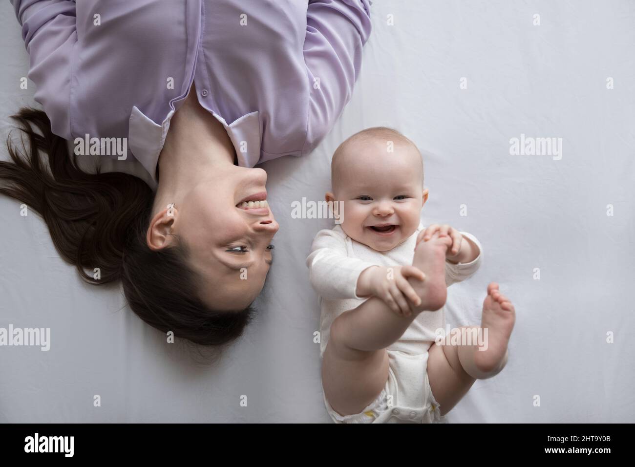 Happy mom and positive adorable few month baby resting together Stock ...