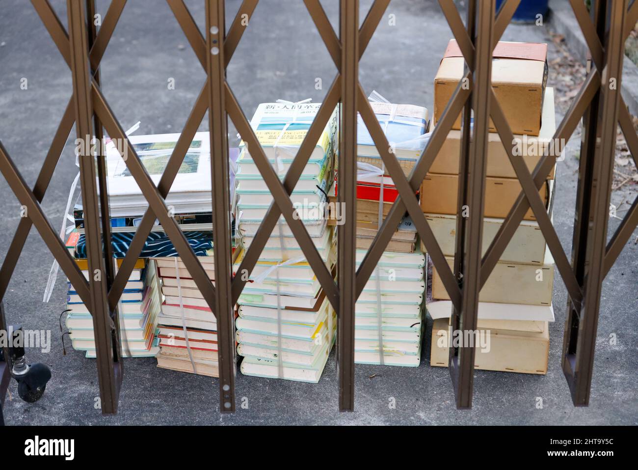 Stacks of old books bundled behind driveway gate Stock Photo - Alamy