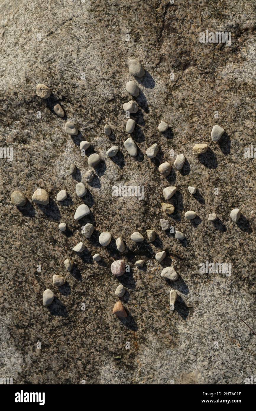 The sun made up of smooth pebbles on a stone surface Stock Photo - Alamy