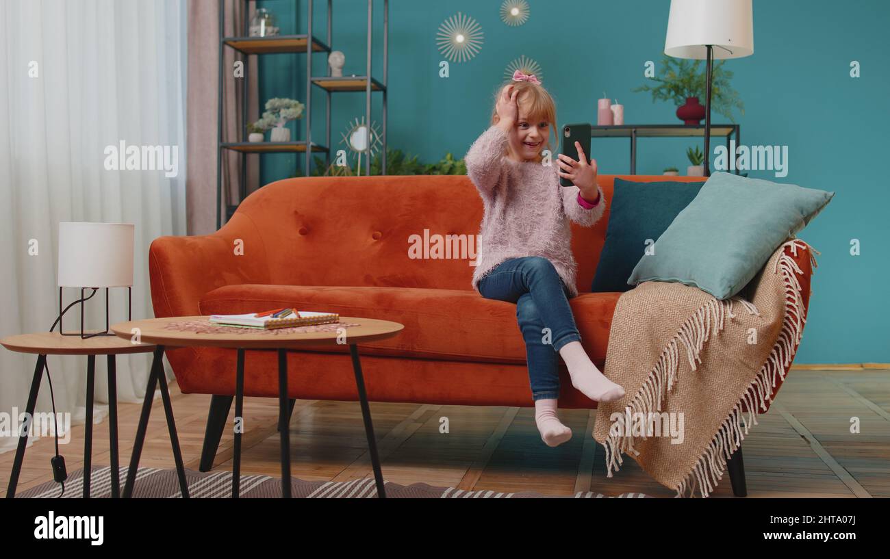 Excited amazed winner kid girl use mobile phone say wow yes raising ...