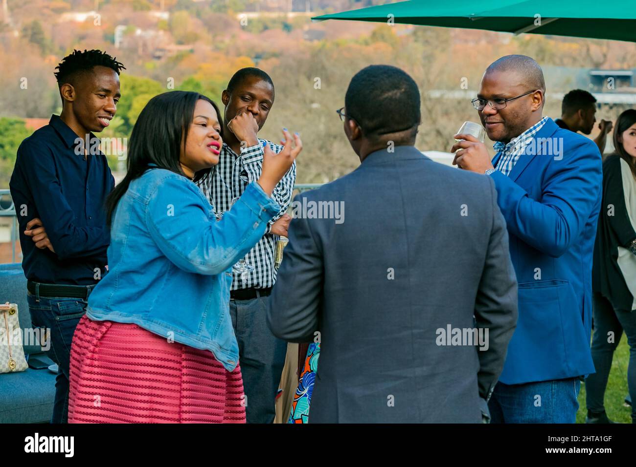 A number of VIP guests mingling at an outdoor social event in ...