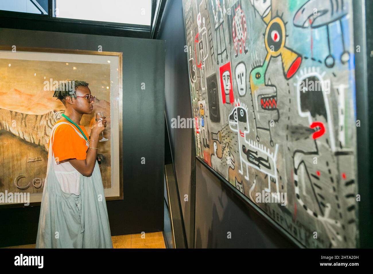 Close-up shot of a fashionable visitor viewing art exhibit in gallery ...