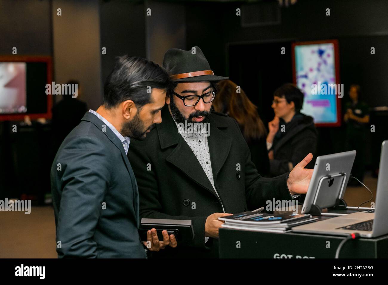 Vendors demonstrating a product service at a retail industry conference ...