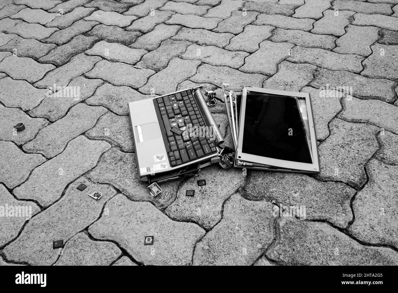 Grayscale shot of a broken laptop computer on brick paving Stock Photo ...