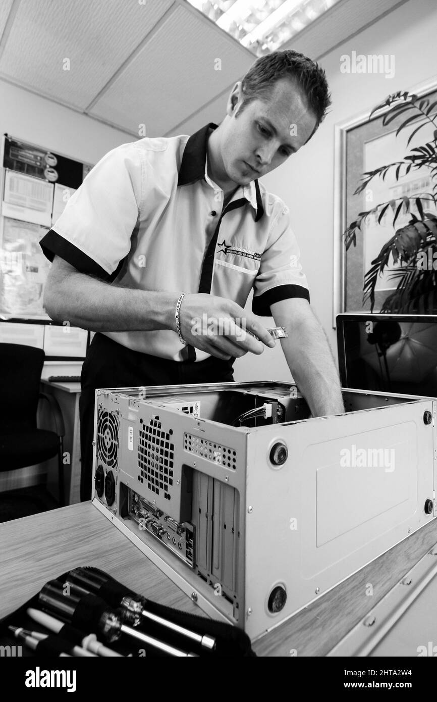 IT service and maintenance professional working on a desktop computer ...