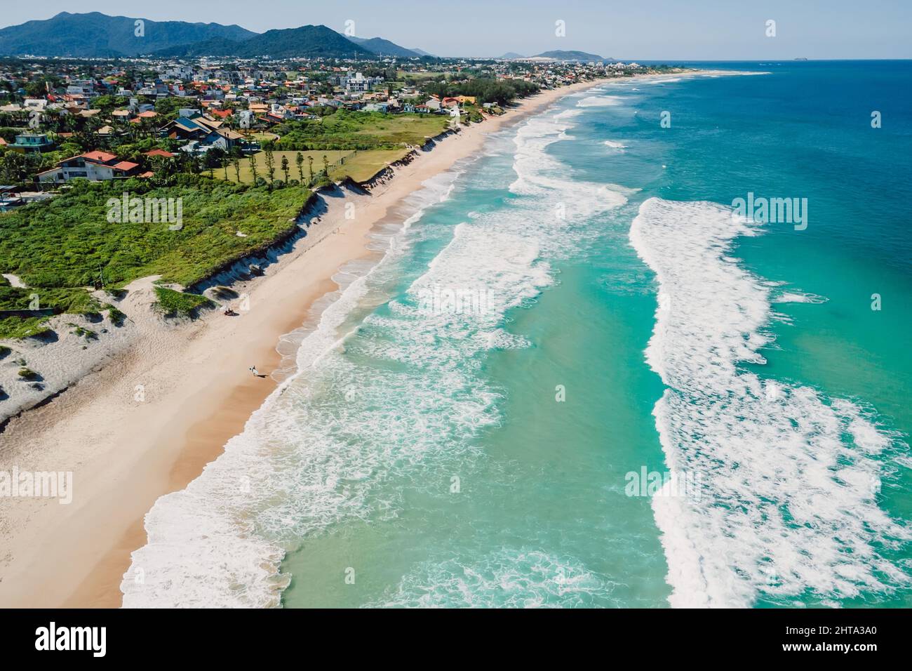 Holiday beach and blue ocean with waves in Brazil. Aerial view of Morro ...