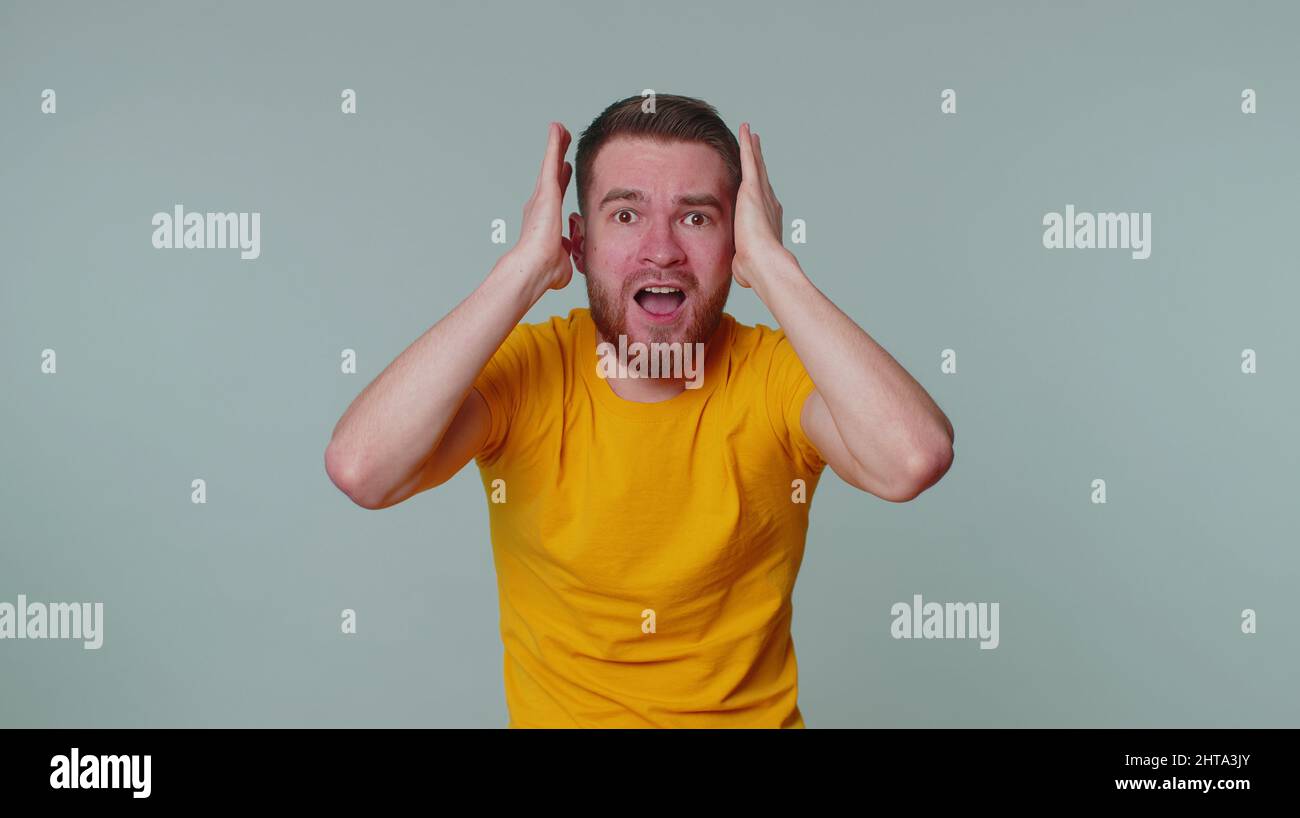 Bearded adult man scared fearful, covering ears with hands, closing ...