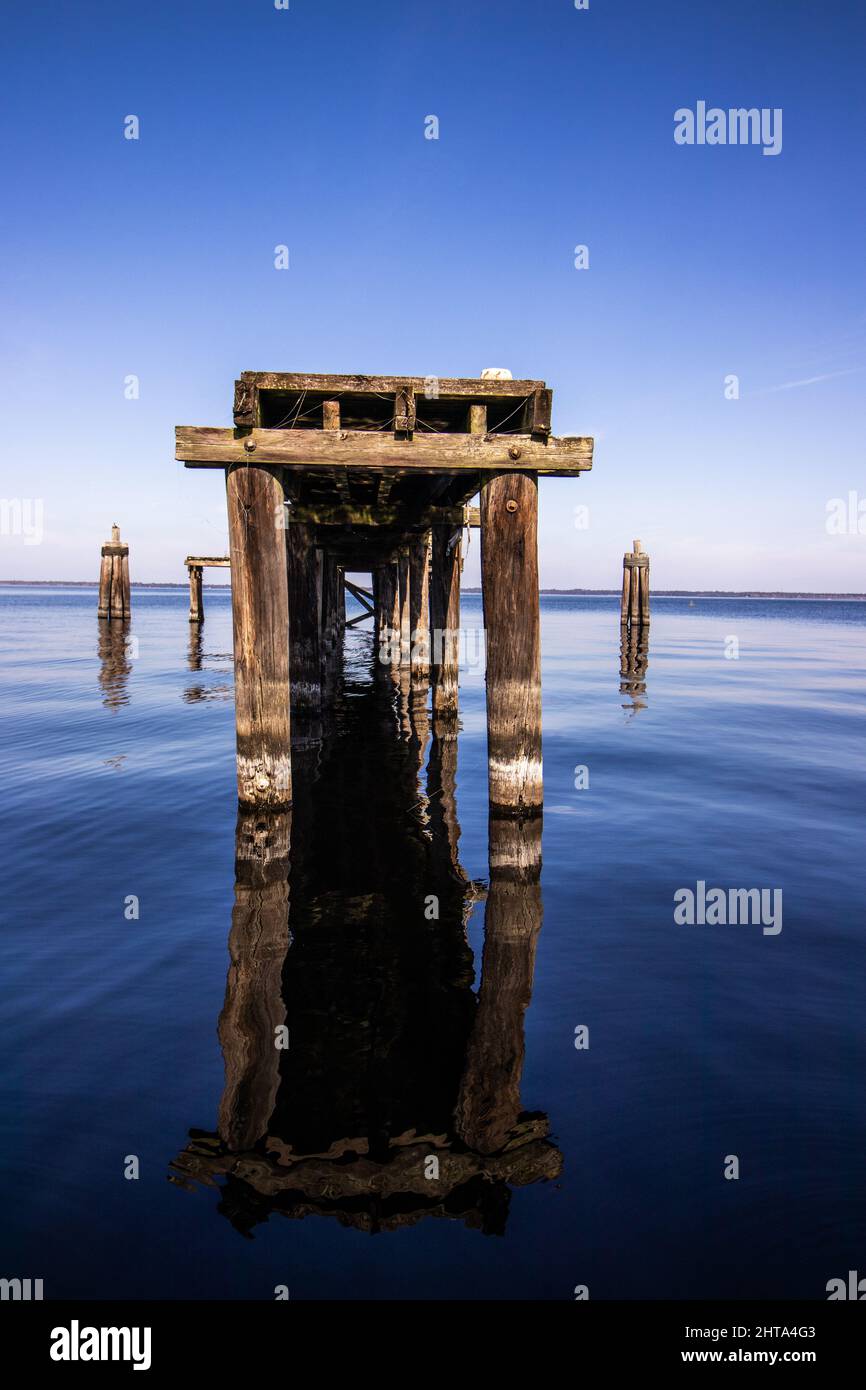 Vertical shot of a tall wooden port structure in blue water Stock Photo ...