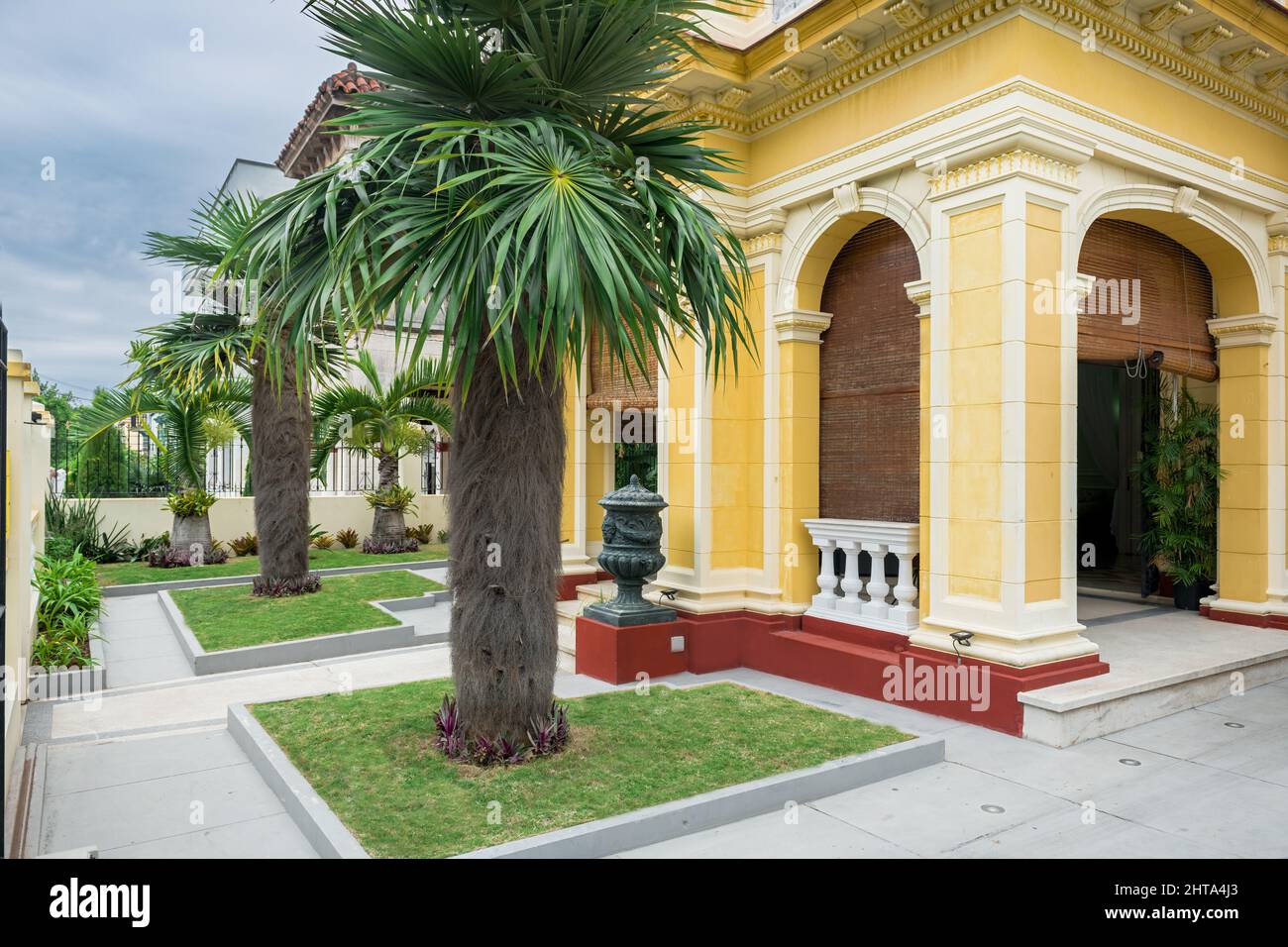 Partial view of a classic home on a tropical place with palm tress ...