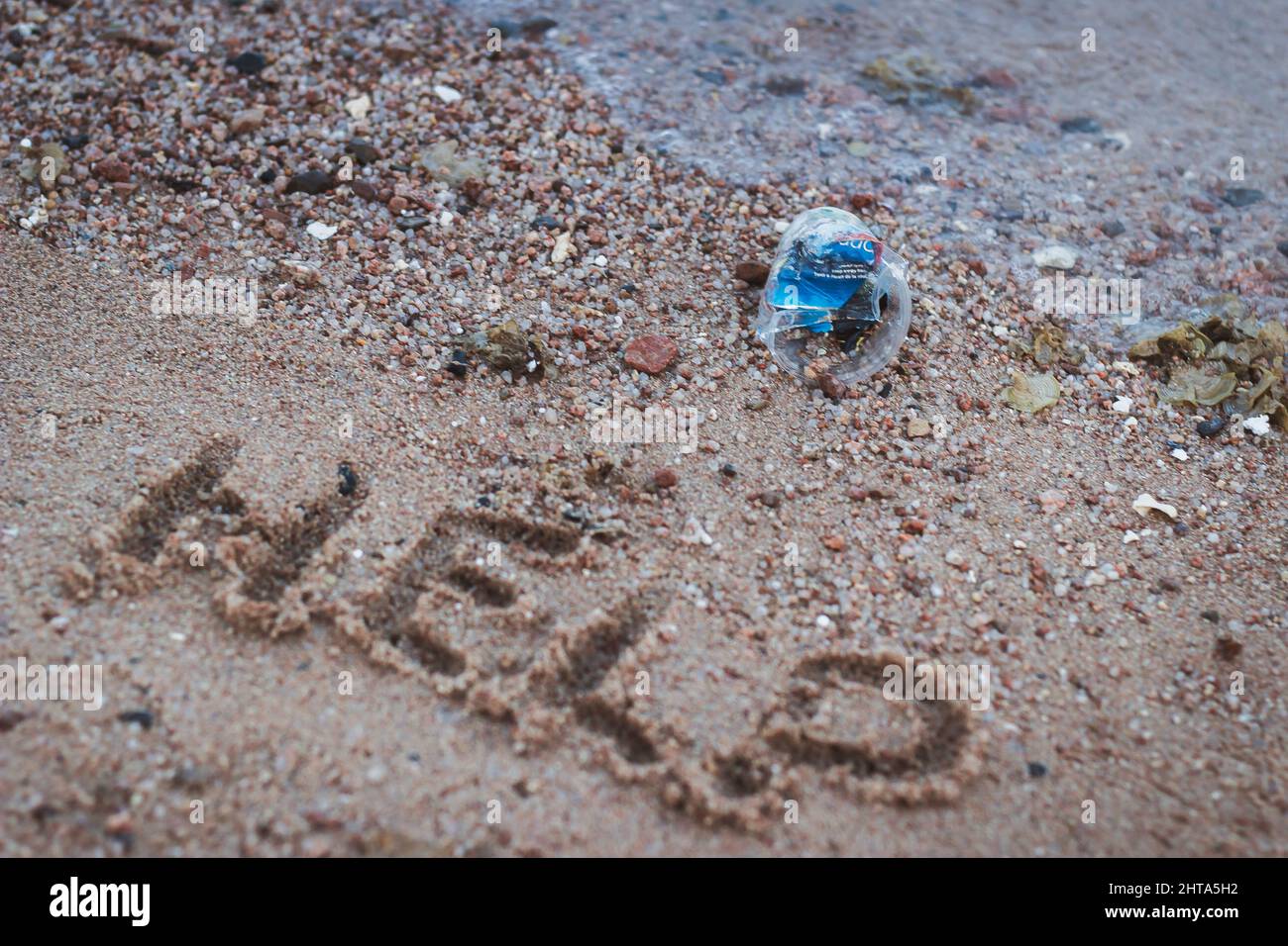 Help message written on the beach next to plastic waste Stock Photo - Alamy