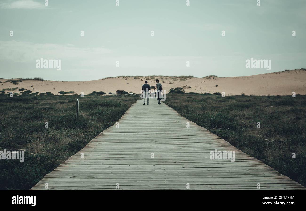 Caucasian boys walking on the wooden walkway Stock Photo - Alamy