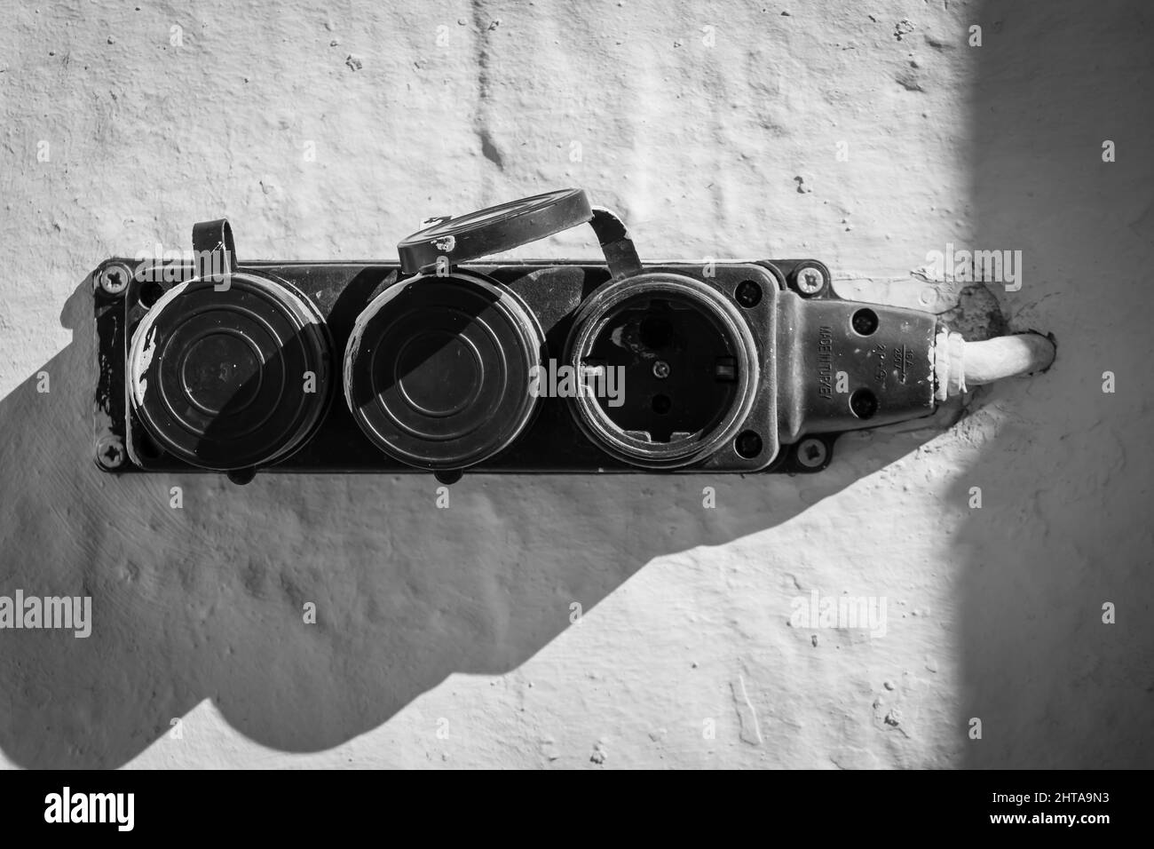 Old black electrical outlet on a white wall Stock Photo - Alamy