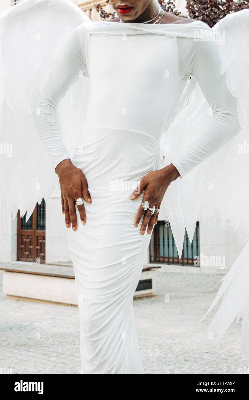 Shot of cut face model wearing white dress with angel wings and posing ...
