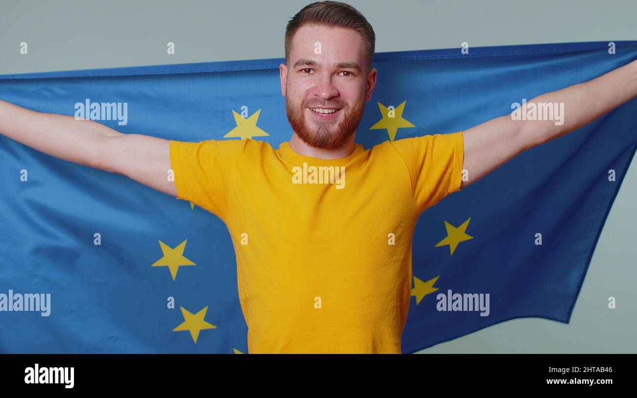 Man waving European Union flag, smiling, cheering democratic laws ...