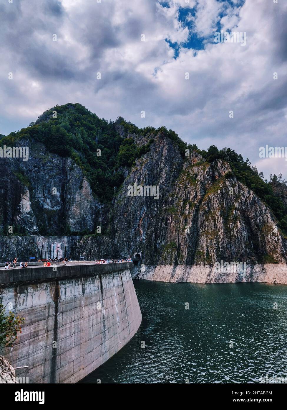 Vertical shot of the Vidraru lake and dam under the cloudy sky in ...