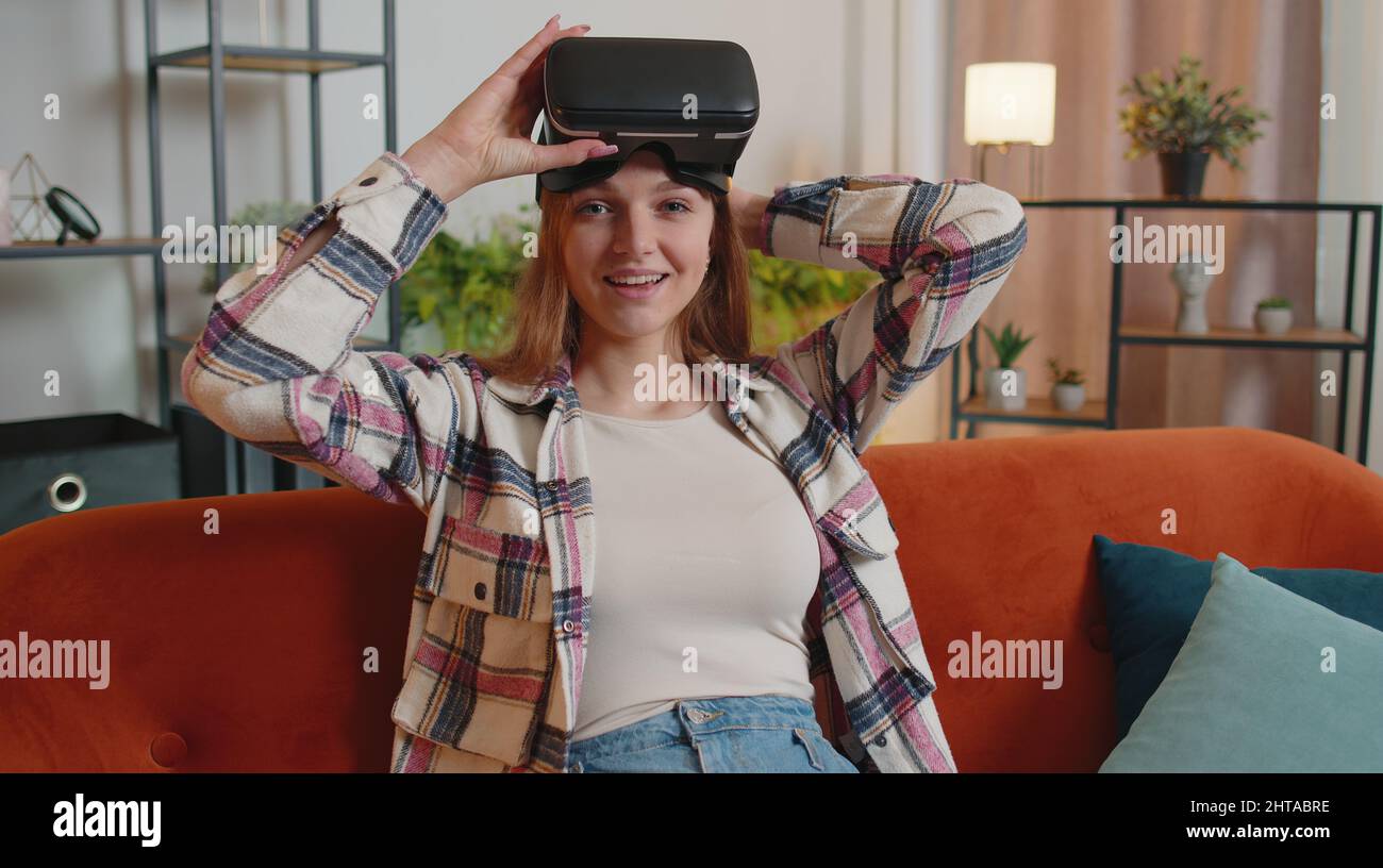 Young woman use virtual reality headset glasses at home, enjoying video ...