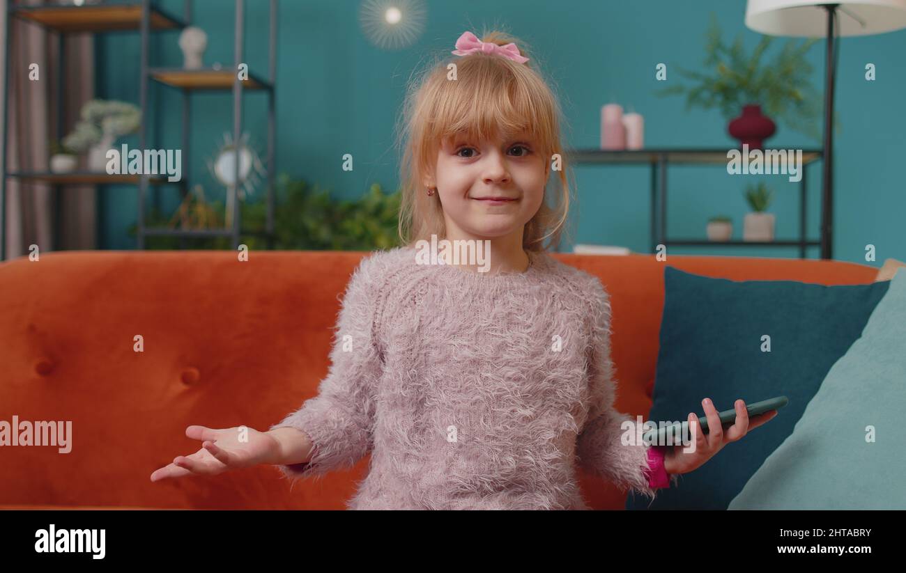 Excited amazed winner kid girl use mobile phone say wow yes raising ...