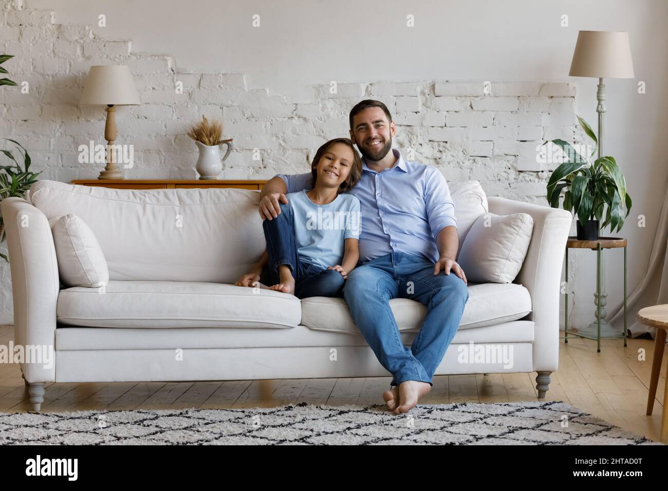 Little boy young father sit on sofa look at camera Stock Photo - Alamy