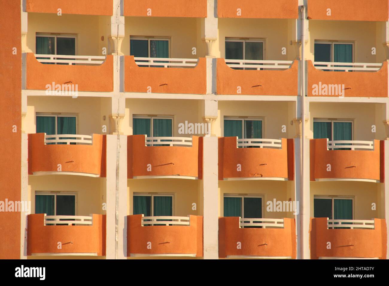 Closeup of glass windows and balconies of a modern orange building in ...