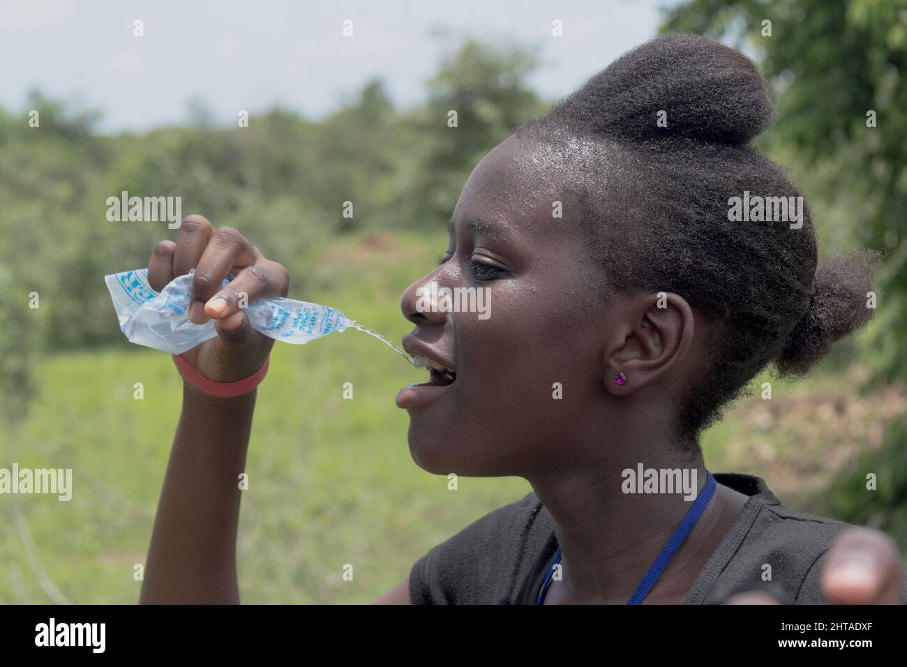Portrait of a thirsty young African girl drinking water Stock Photo - Alamy