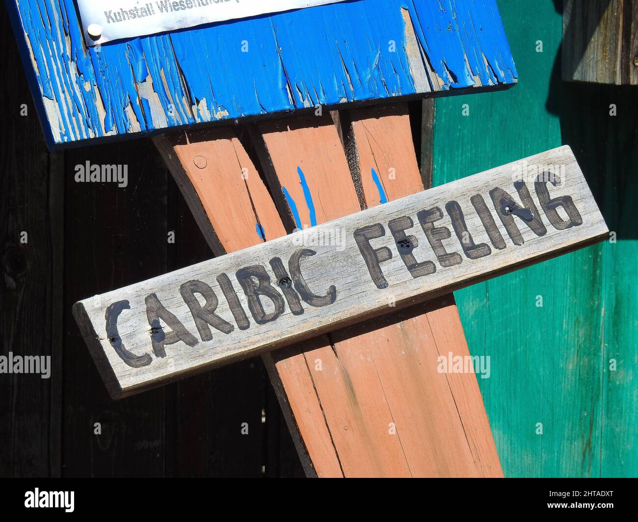 Wooden colorful signboard with text "caribic feeling Stock Photo - Alamy