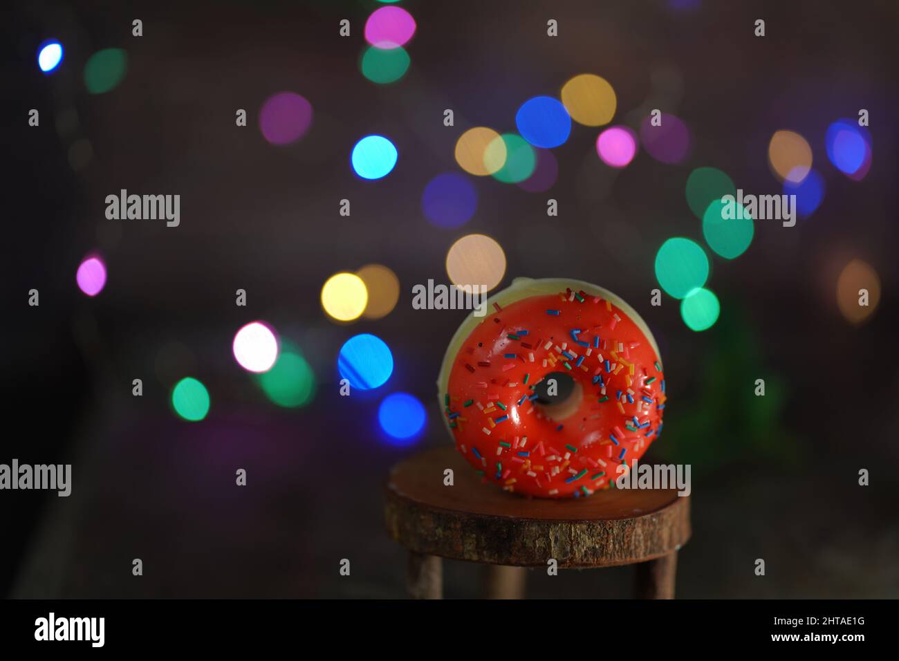Selective focus of a red donut with bokeh lights on the background ...