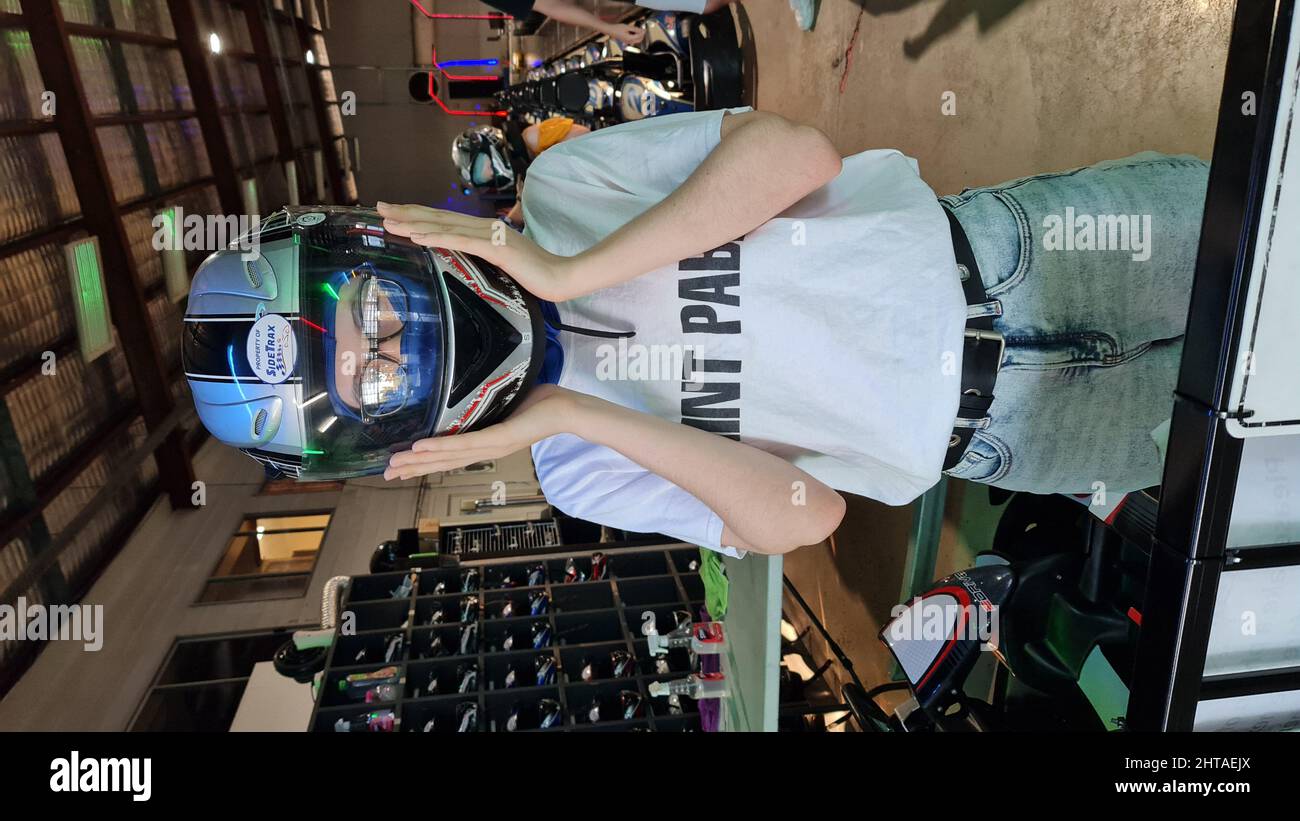 Vertical shot of a young girl wearing a helmet ready to go-kart drive ...