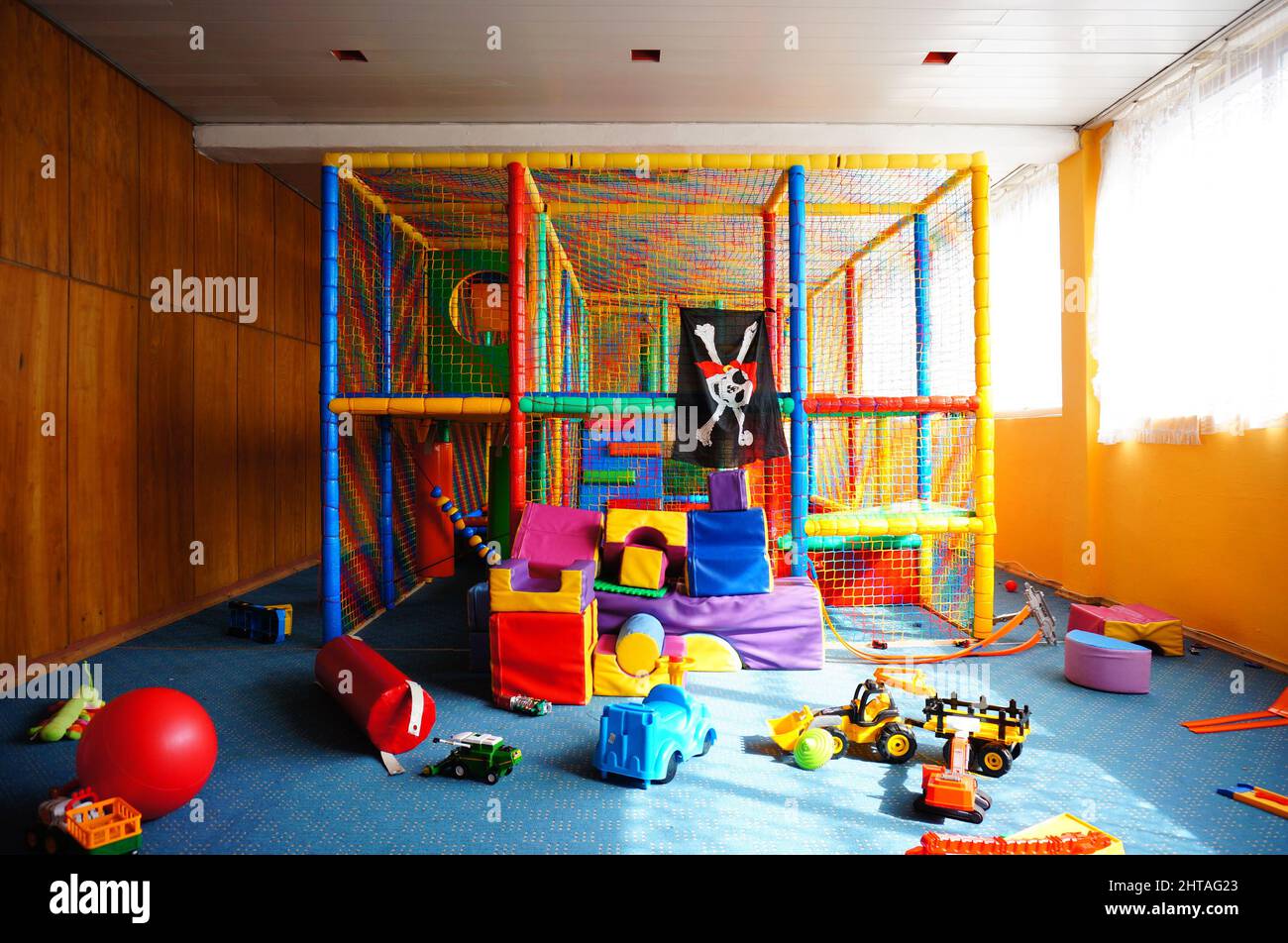 Messy playroom with toys scattered on the blue carpet floor and a ...