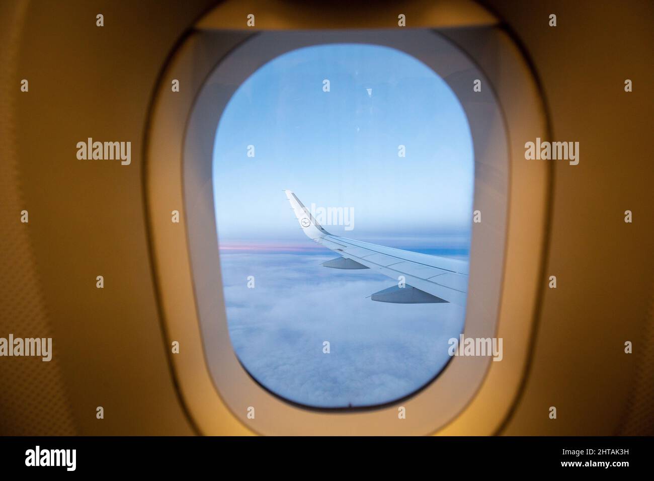 Airplane wing in the clouds captured through the airplane window with ...