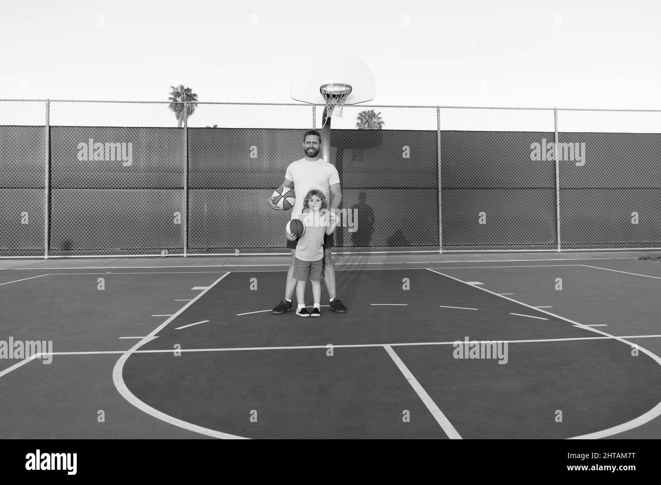 happy family. dad and kid boy play basketball. child hold sport ball ...