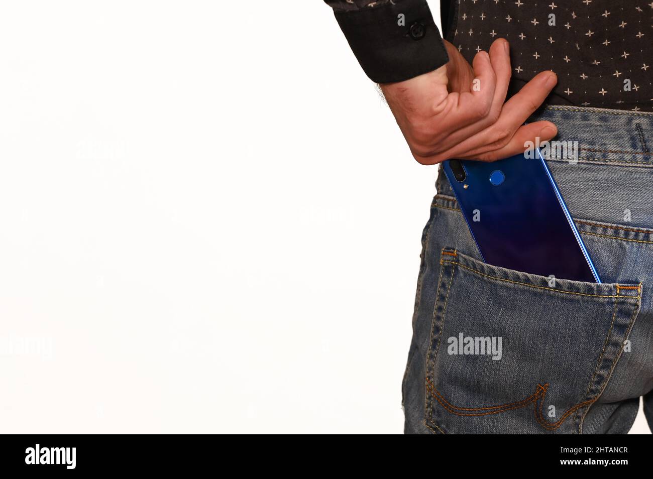 man puts out a smartphone from the back pocket. on a white background ...