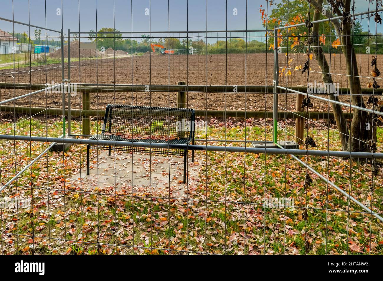 Metal bench in a metal fence near an agricultural field Stock Photo - Alamy
