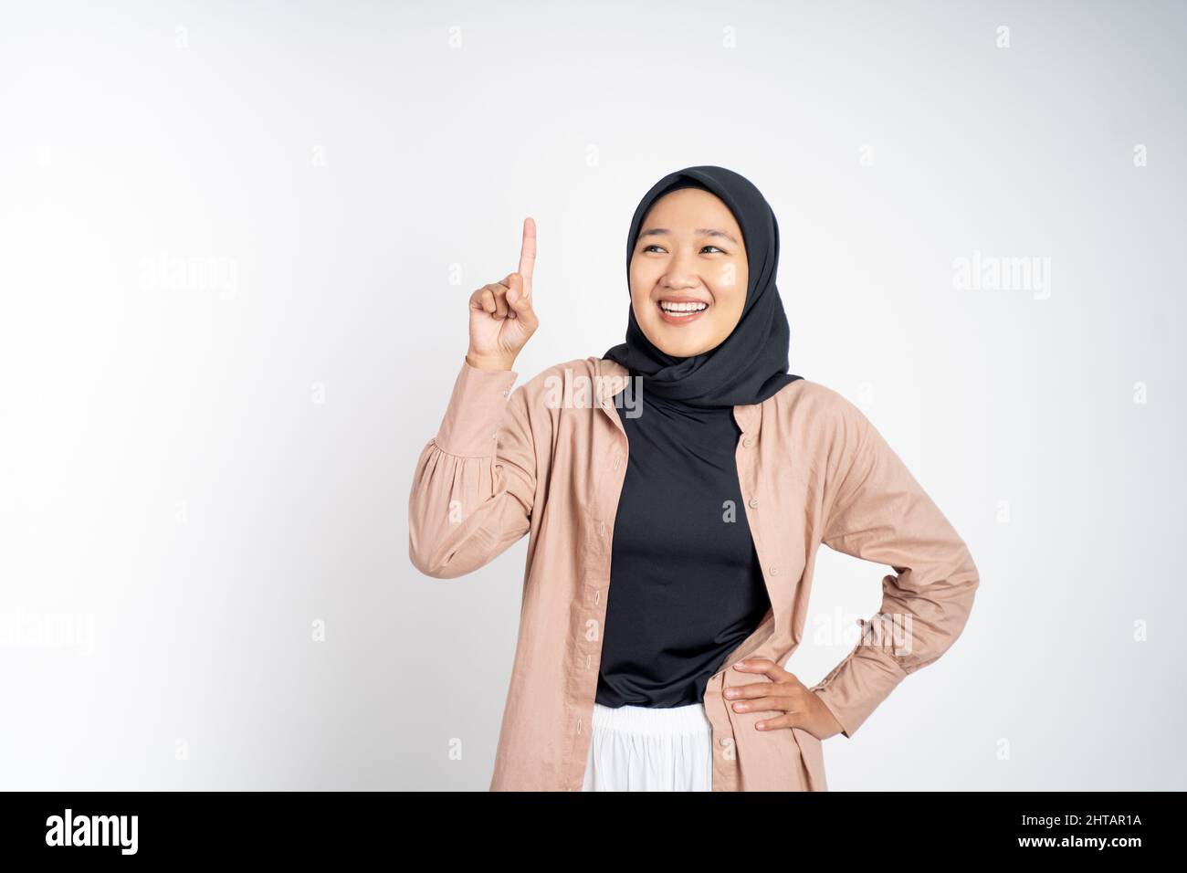 Smiling hijab woman with finger pointing up hand gesture Stock Photo ...