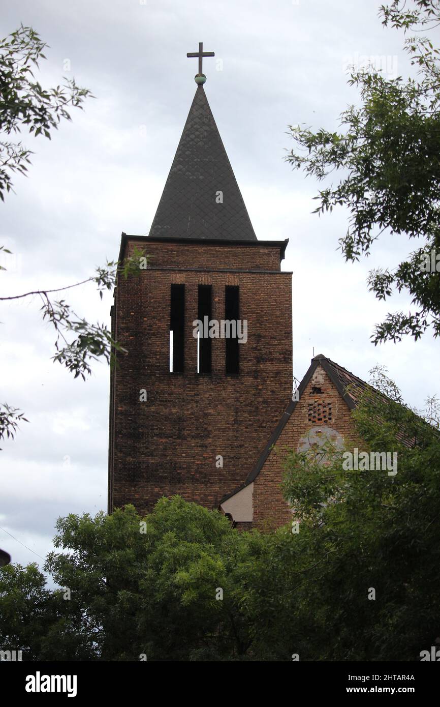 Vertical shot of an old church rooftop with a cross on a sky background ...