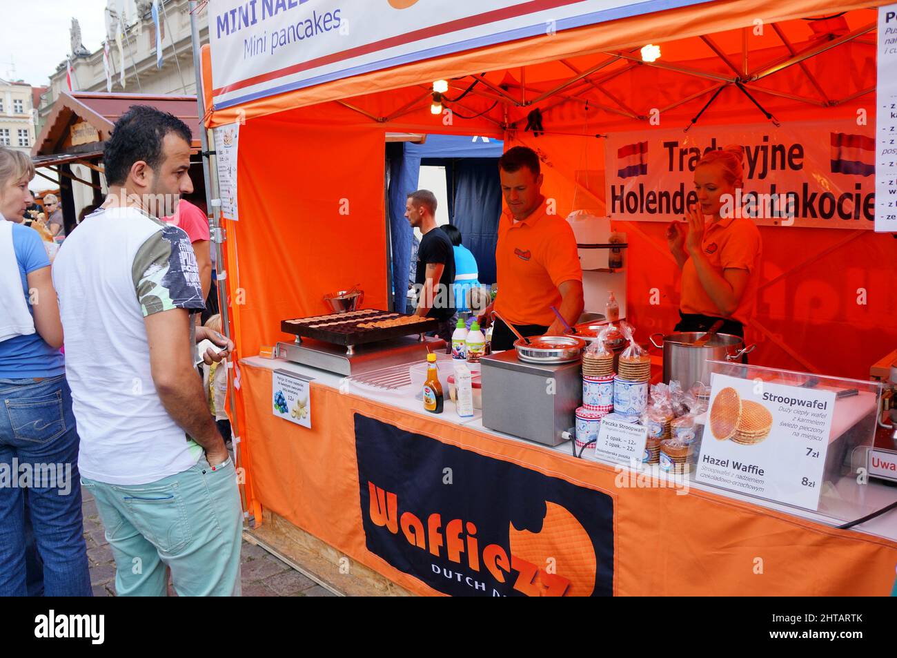 Man selling waffles at a food market in the old city square Stock Photo ...