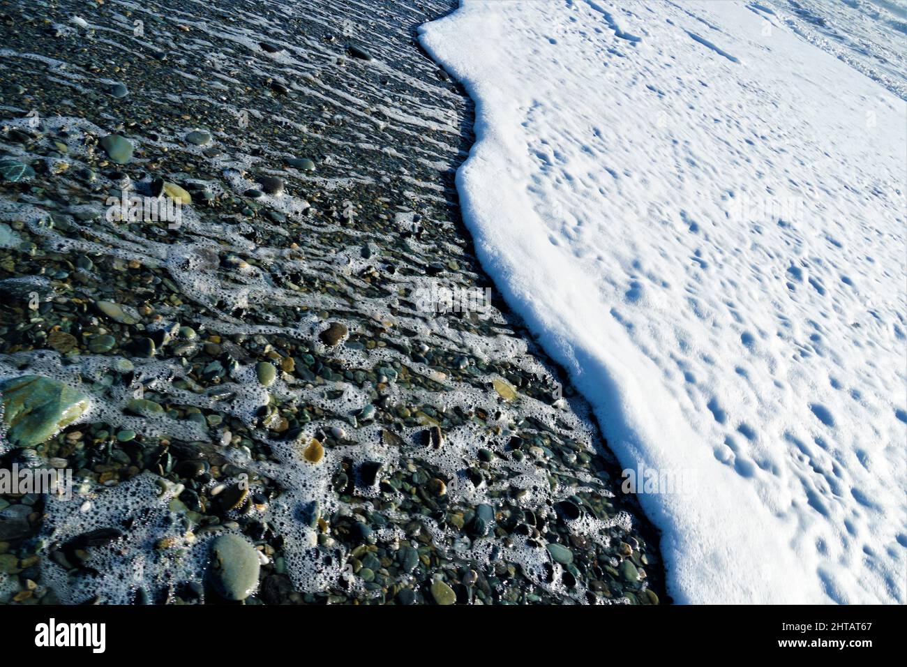 Close-up shot of a sea wave covering mall stones on Awatuna beach Stock ...