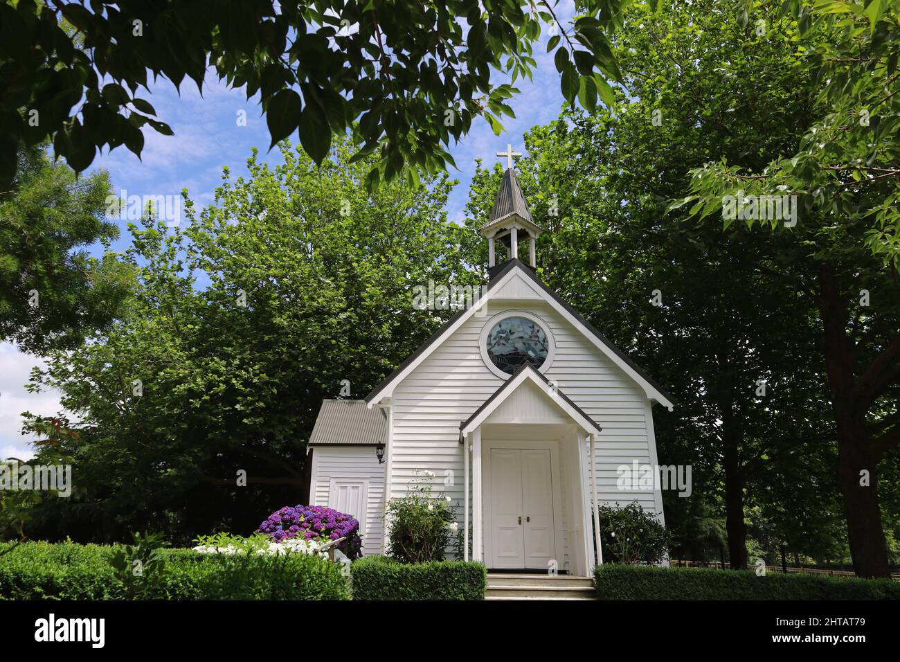 Beautiful small church surrounded by trees and flower garden Stock ...