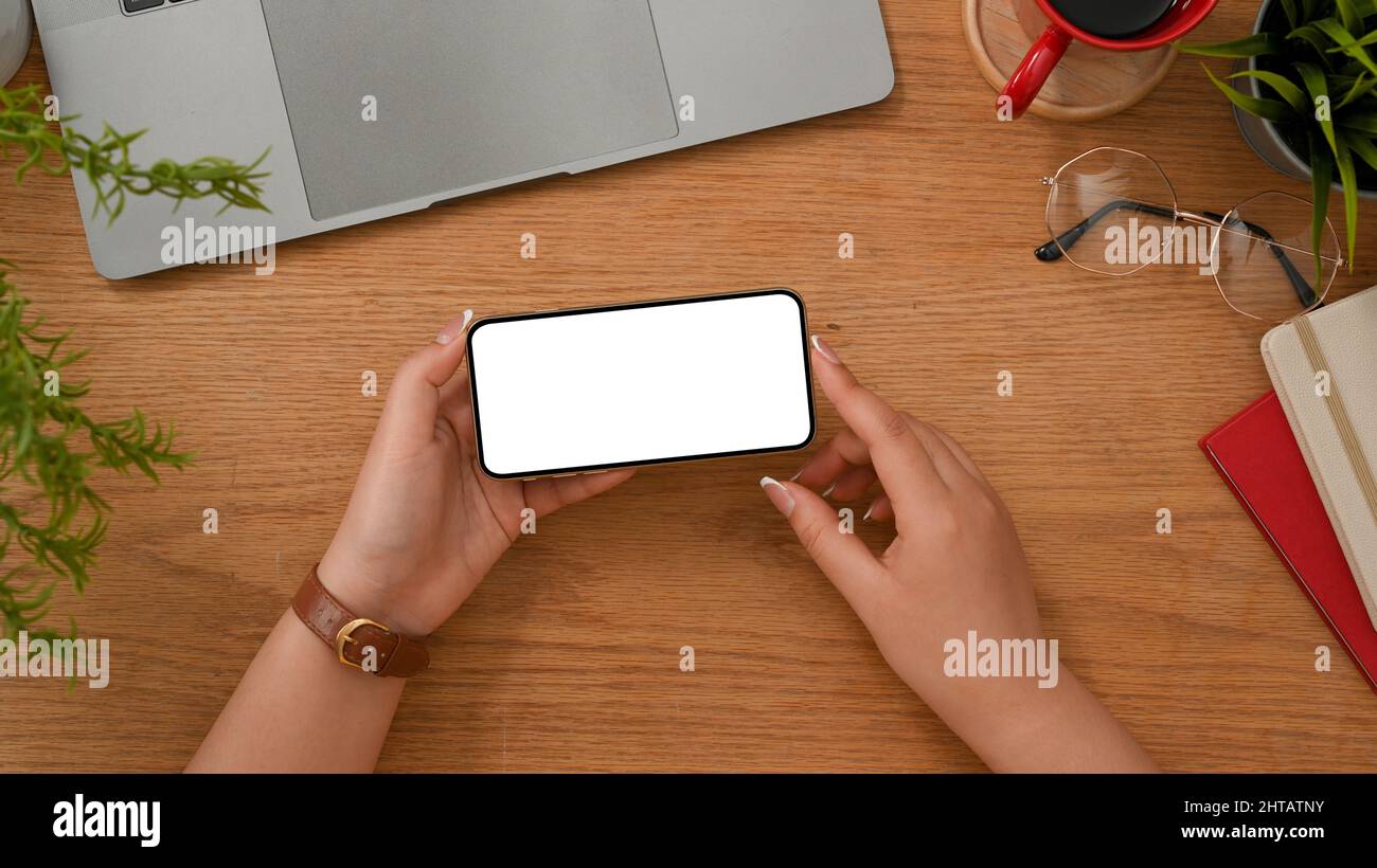 Close-up, top view, Woman holding a smartphone empty screen on table ...