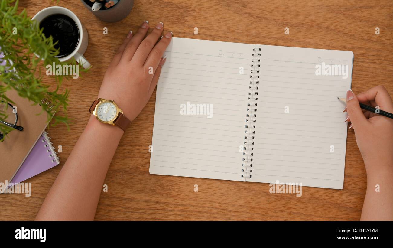 Female university student doing her homework on a school notebook ...