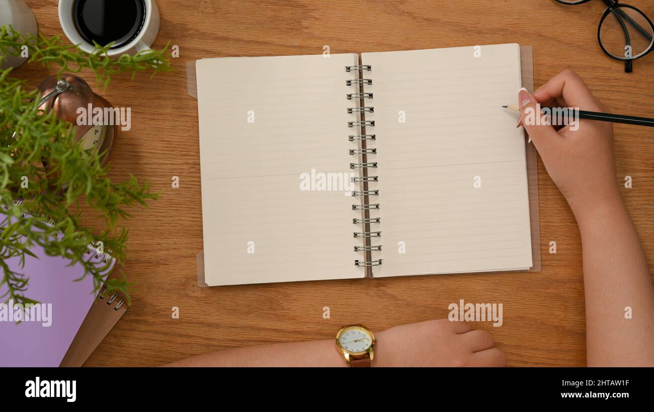 Female taking notes, making a lecture, writing a diary in spiral ...