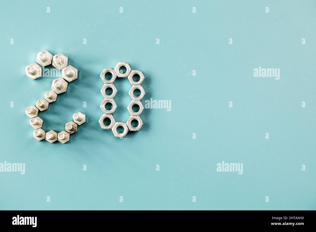 "20" number designed with bolts and nuts isolated on a light blue ...