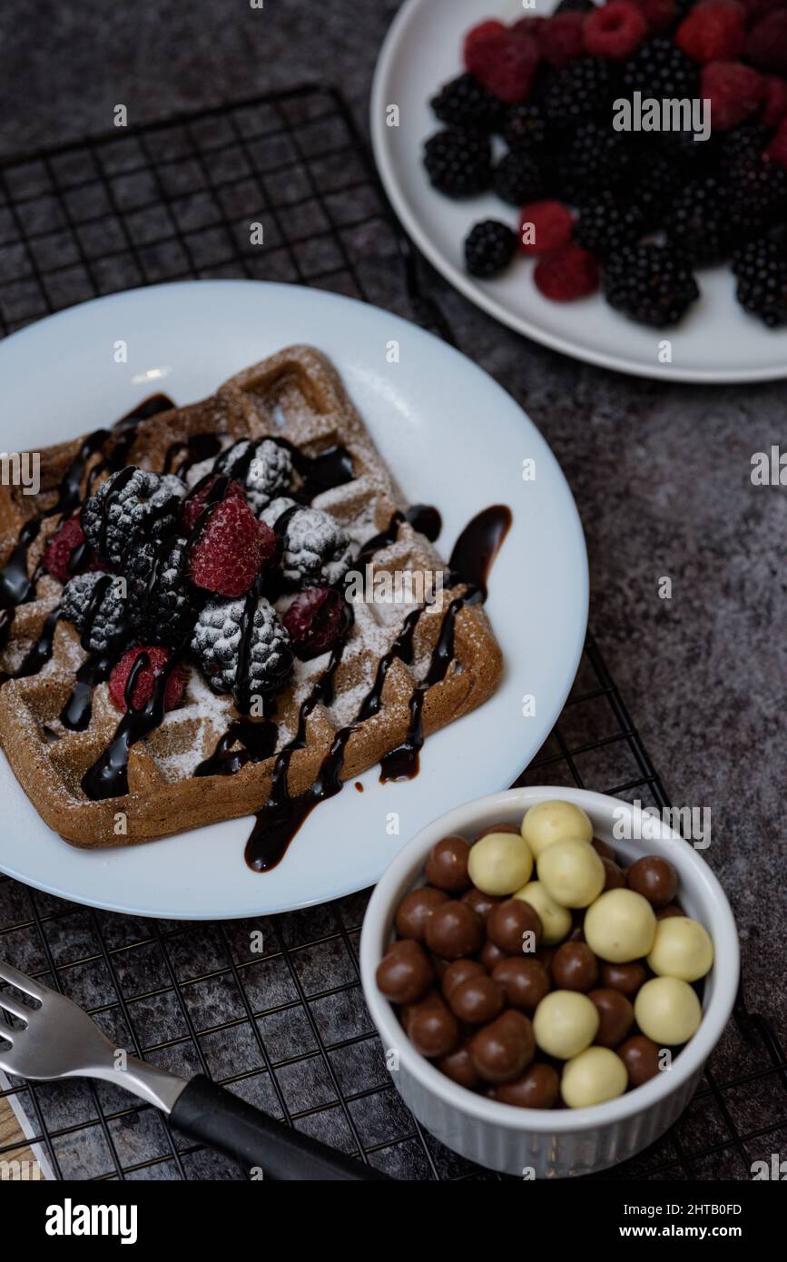 Photo of chocolate waffle with raspberries, a bowl of chocolate, and ...