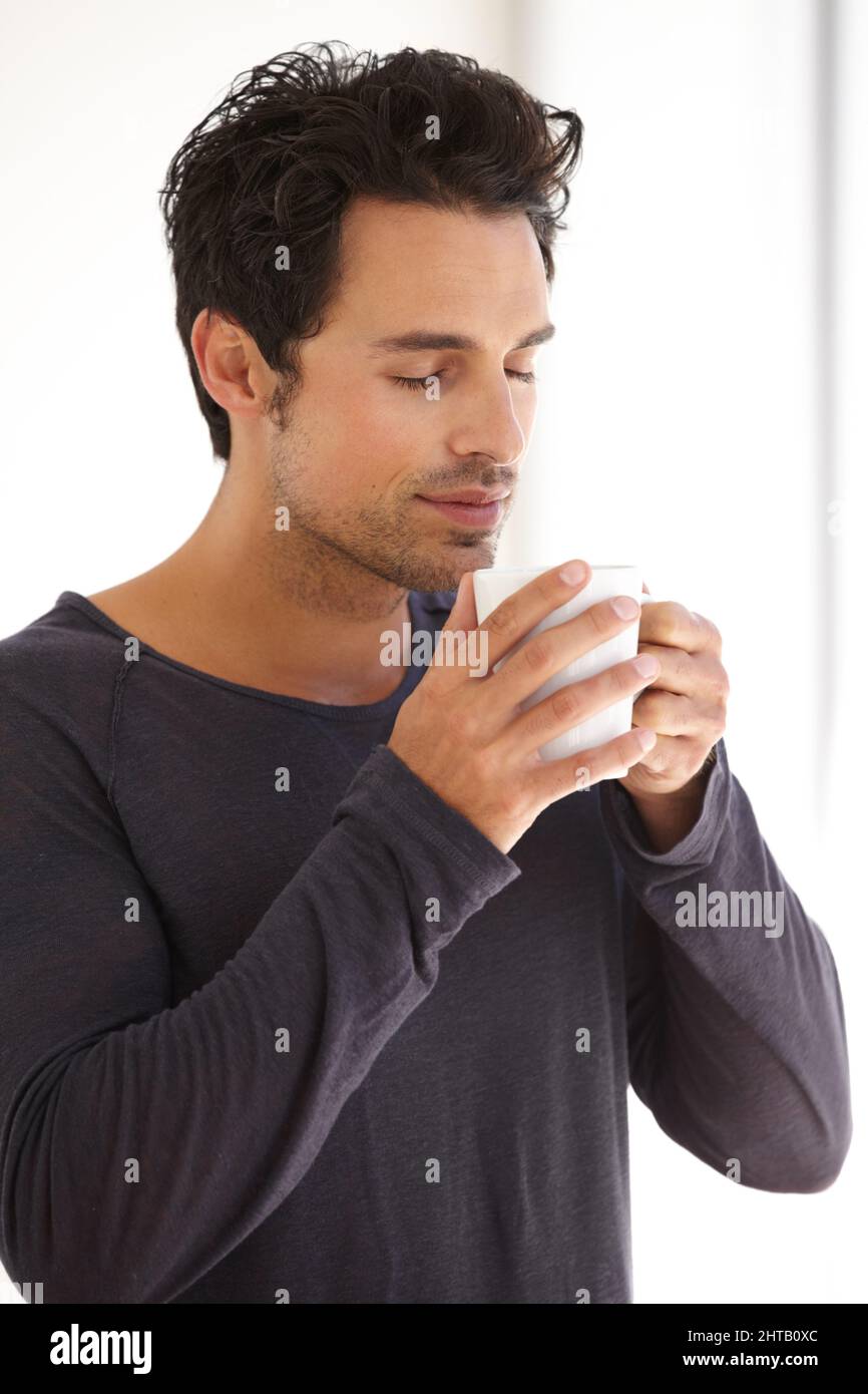 The first cup. A handsome young man taking in the aroma of his morning ...