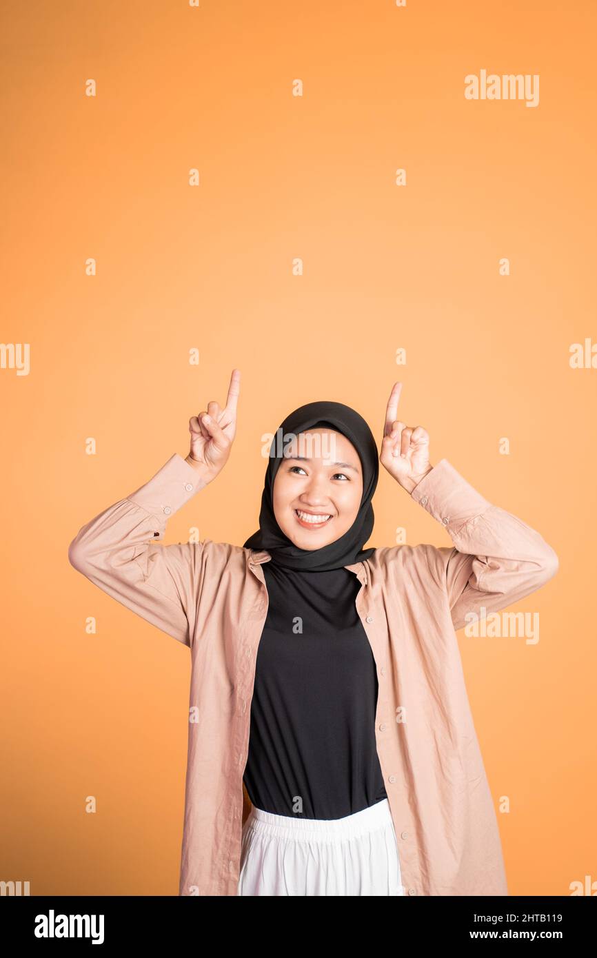 Smiling hijab woman with finger pointing up hand gesture Stock Photo ...