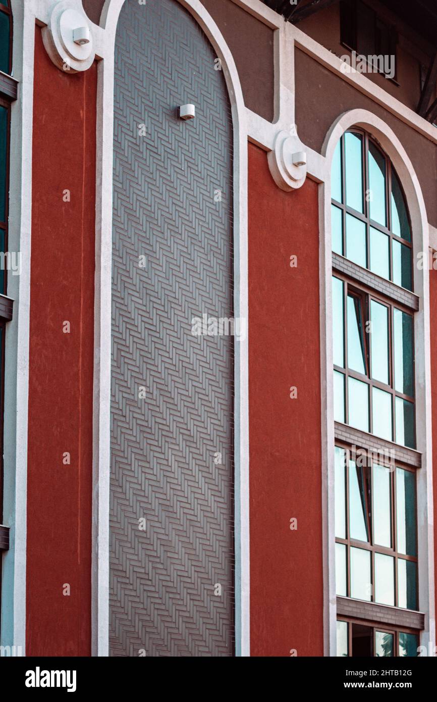 Vertical exterior facade of a modern building with arch glass window ...