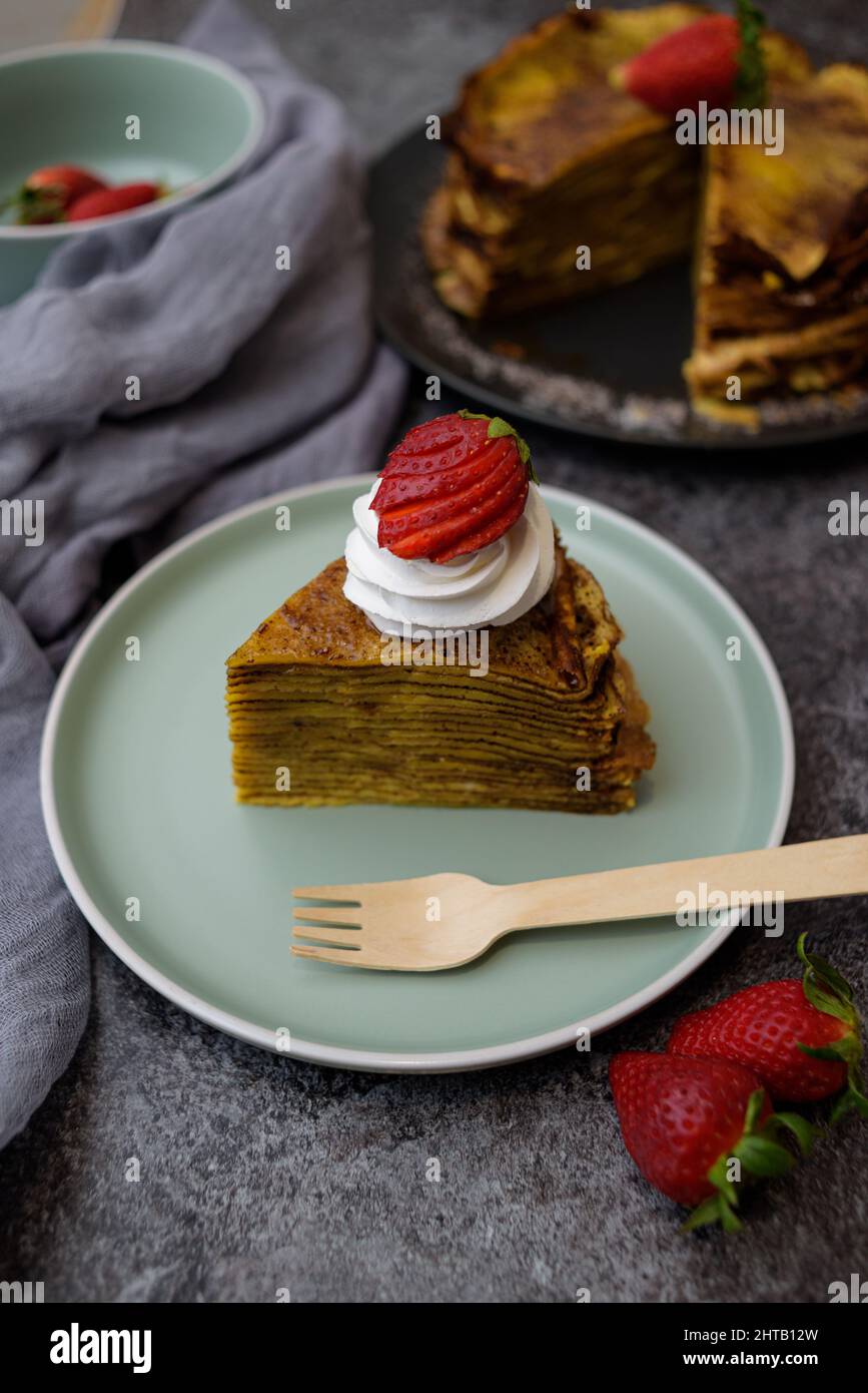 Vertical photo of a piece of pancake cake with whipped cream and ...