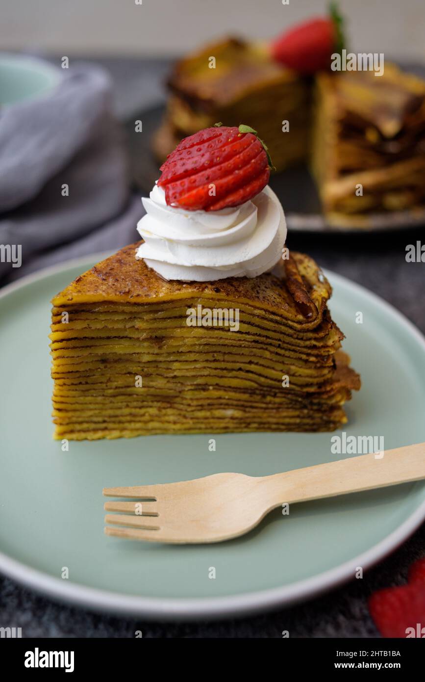 Vertical photo of a piece of pancake cake with whipped cream and ...
